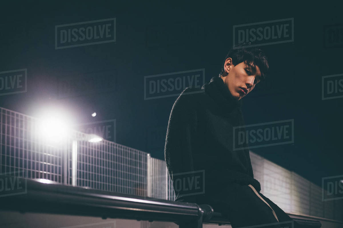 Man leaning against railing waiting, Milan, Italy - Stock Photo - Dissolve