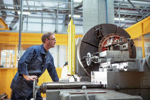 Engineer operating lathe in electrical engineering factory - Stock ...