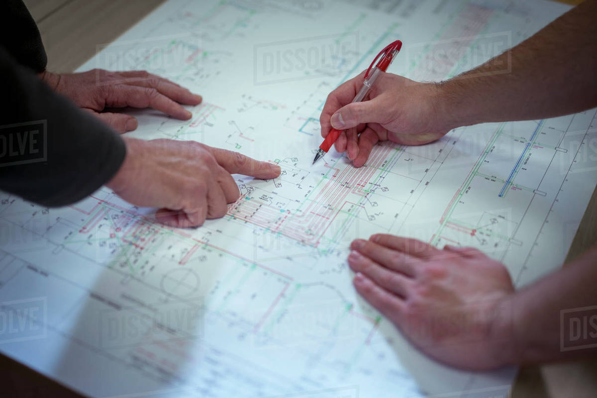 Close up of engineers inspecting drawings in metal fabrication factory ...