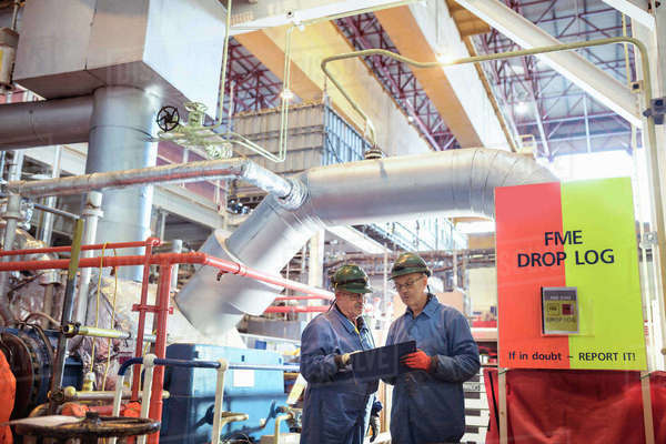 Engineers standing with notes in a nuclear power station. - Royalty ...