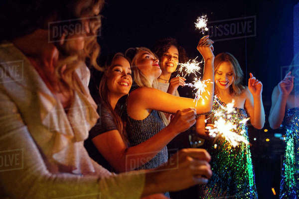 Five women dressed to go out for the evening standing outside with ...