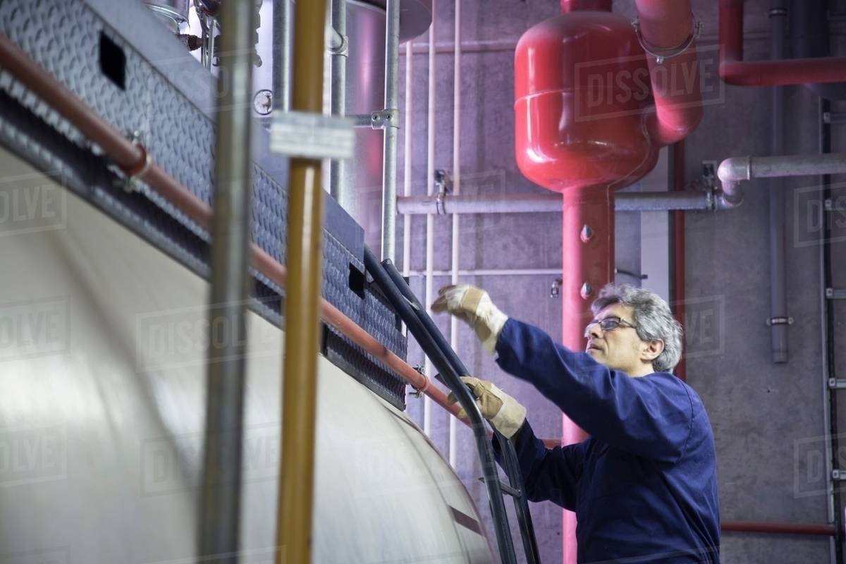 Engineer climbing steps in power station - Stock Photo - Dissolve