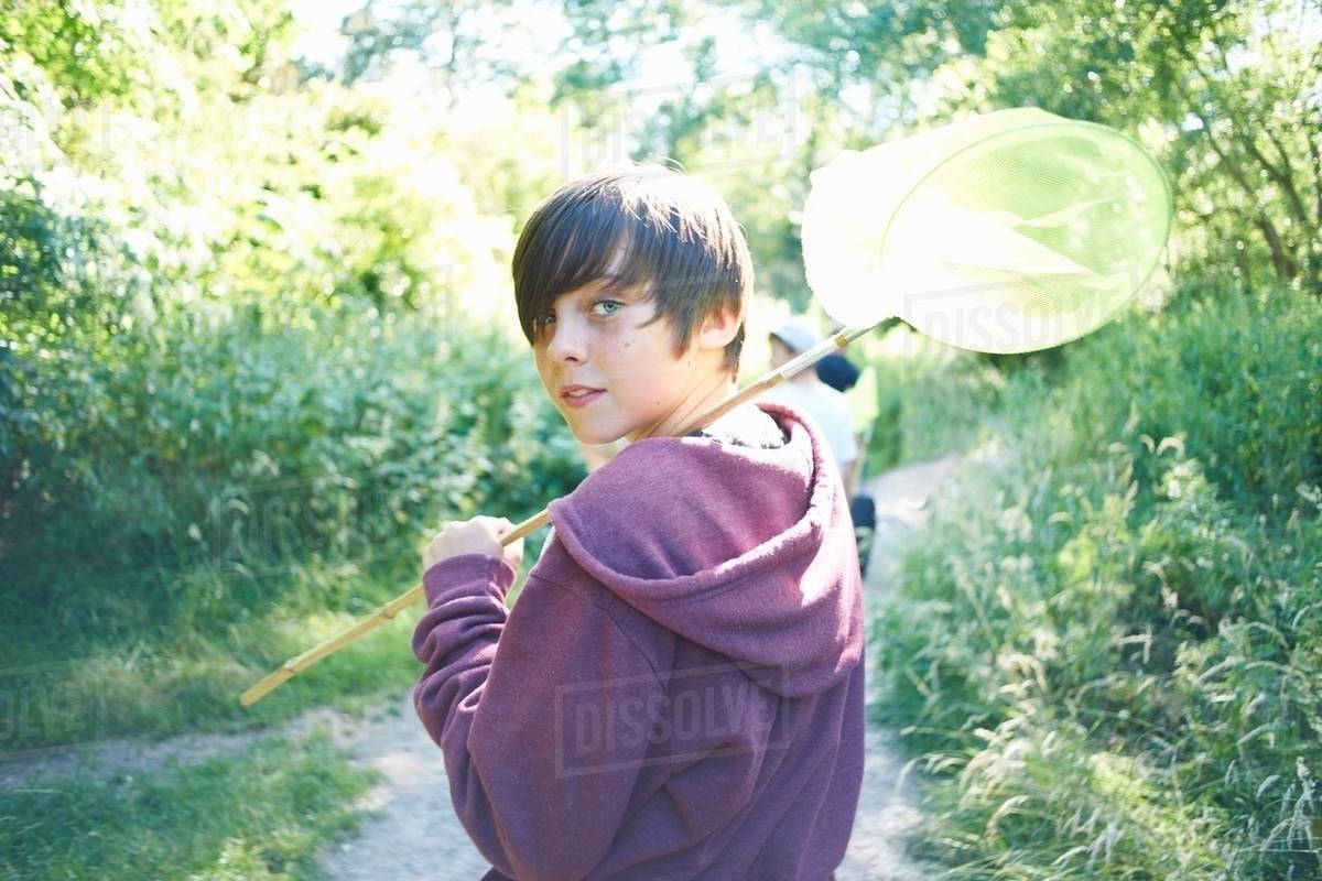 Portrait of boy holding fishing net - Royalty-free Stock Photo | Dissolve