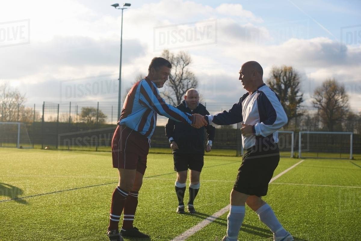 Football players starting game - Stock Photo - Dissolve