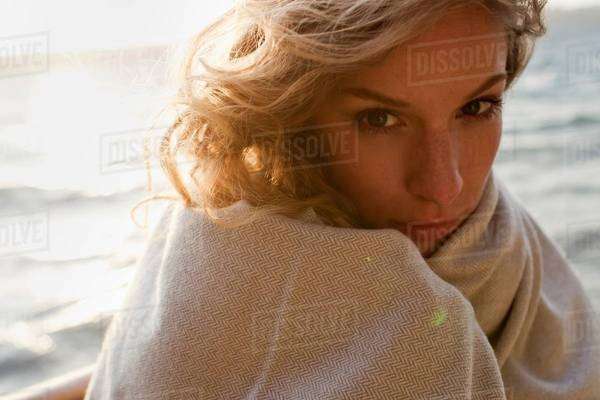 Woman all wrapped up on windy beach - Royalty-free Stock Photo | Dissolve