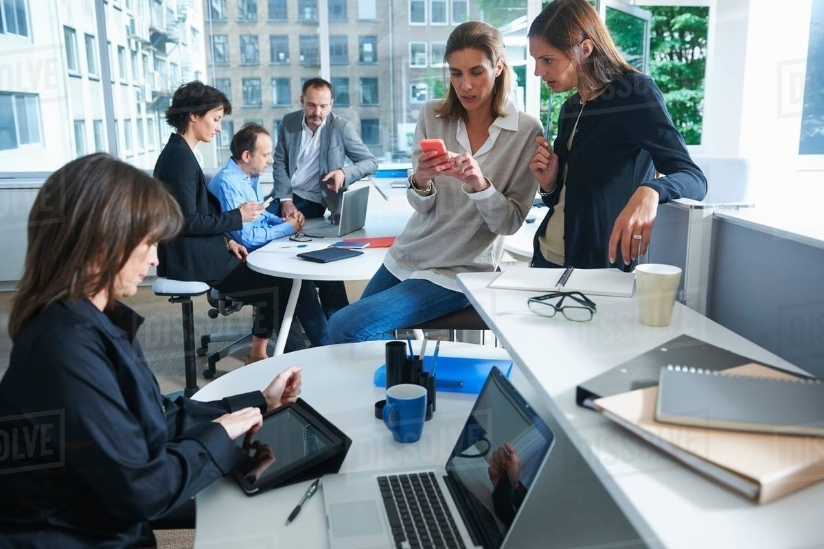 Six businessmen and women working in busy office - Stock Photo - Dissolve