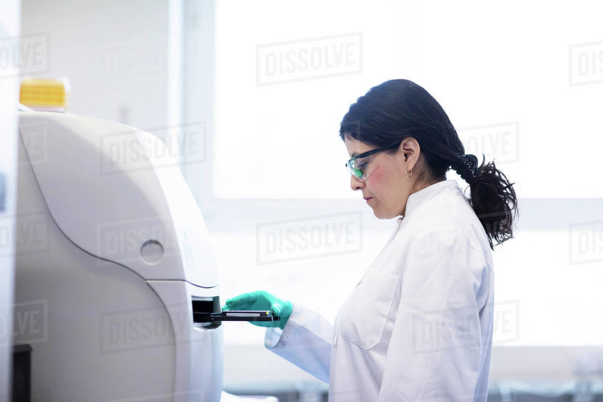 Scientist operating advanced laboratory equipment - Stock Photo - Dissolve