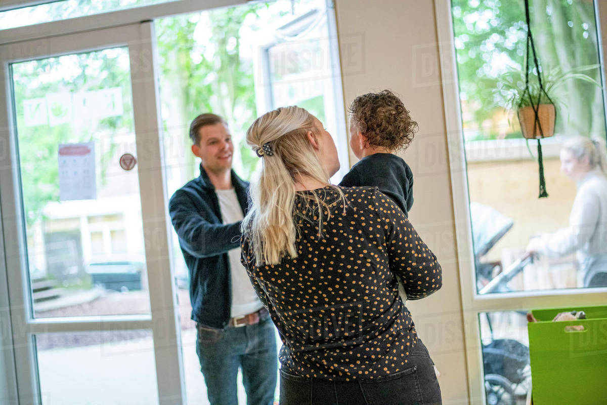 A warm moment as a woman holds a young child while conversing with a ...