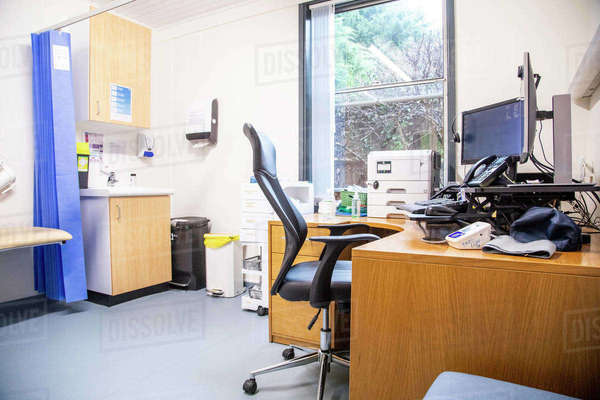 A well-equipped medical examination room with blue patient chair ...