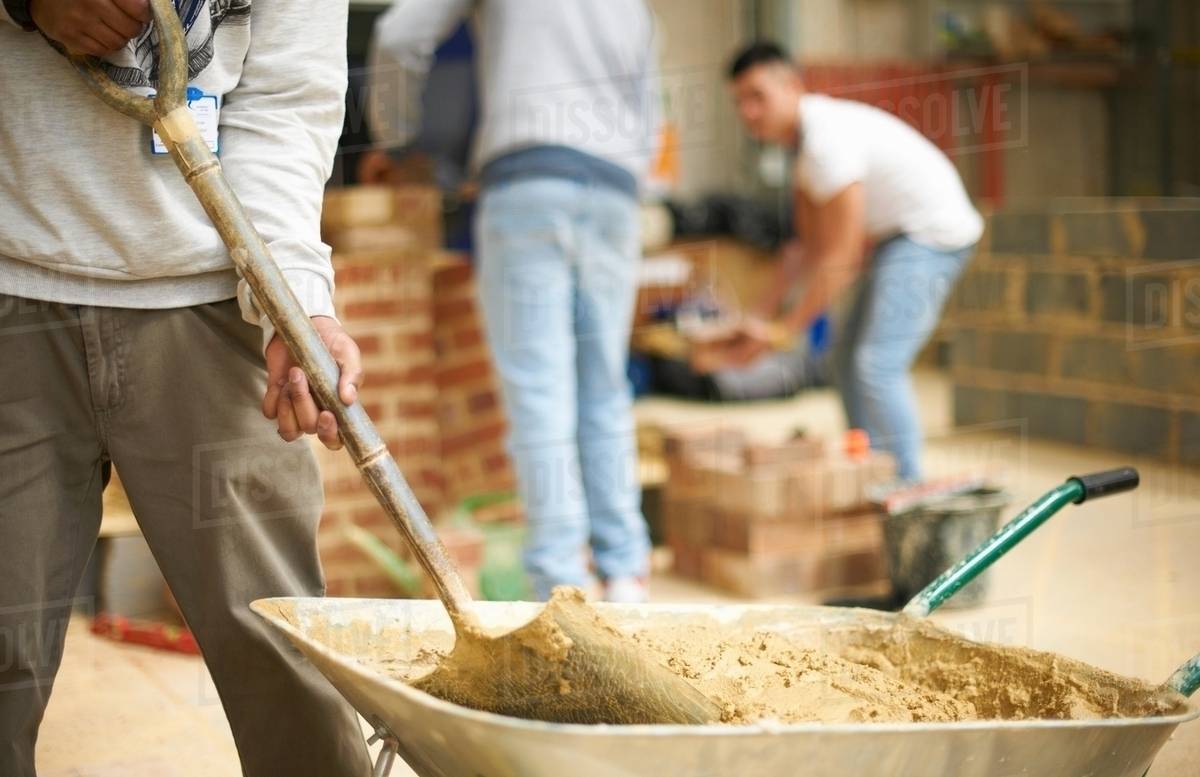 Cropped shot of three male college students in bricklaying workshop ...