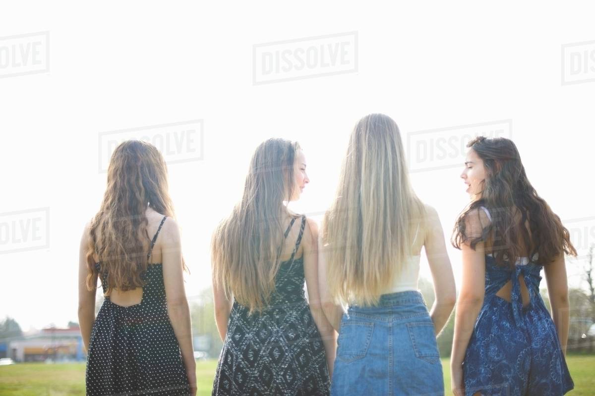 Rear view of four teenage girls chatting in park - Royalty-free Stock ...
