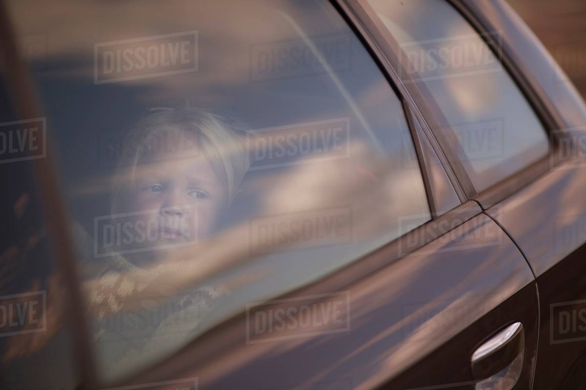 Boy looking through car window - Stock Photo - Dissolve