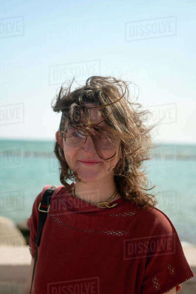 A woman in a wet black swimsuit is emerging from a pool, with water ...