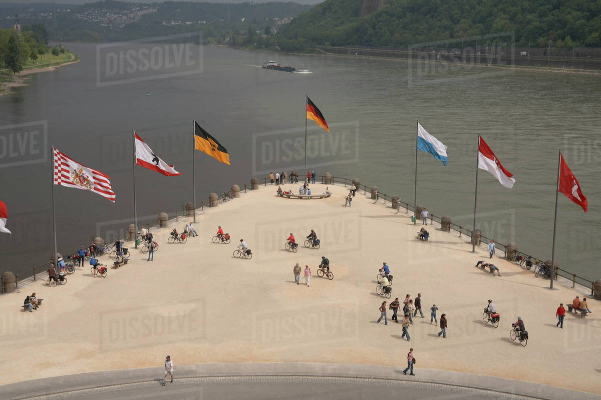 The image shows a scenic viewpoint with people walking and sitting ...