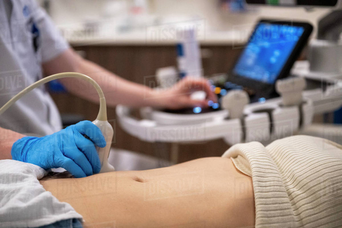 A medical professional performs an ultrasound examination on a patient ...