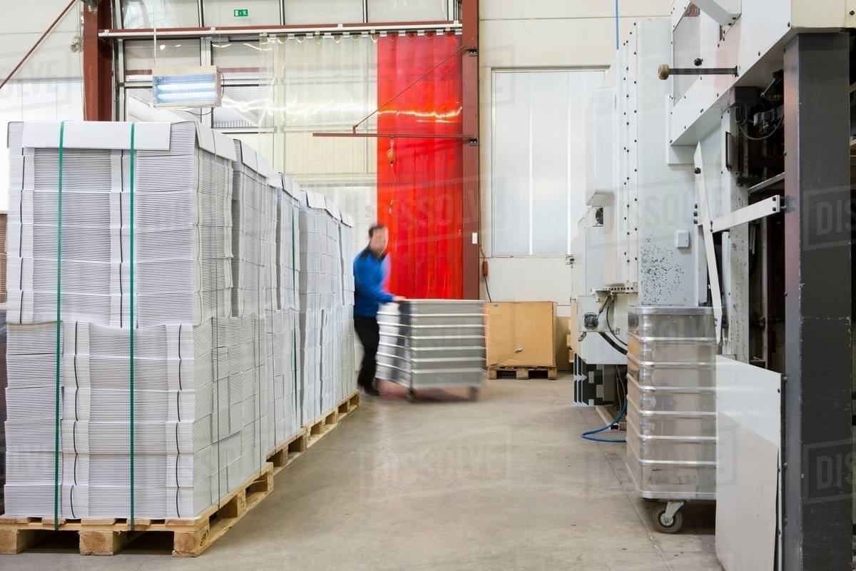 Factory workers moving containers of cardboard - Stock Photo - Dissolve