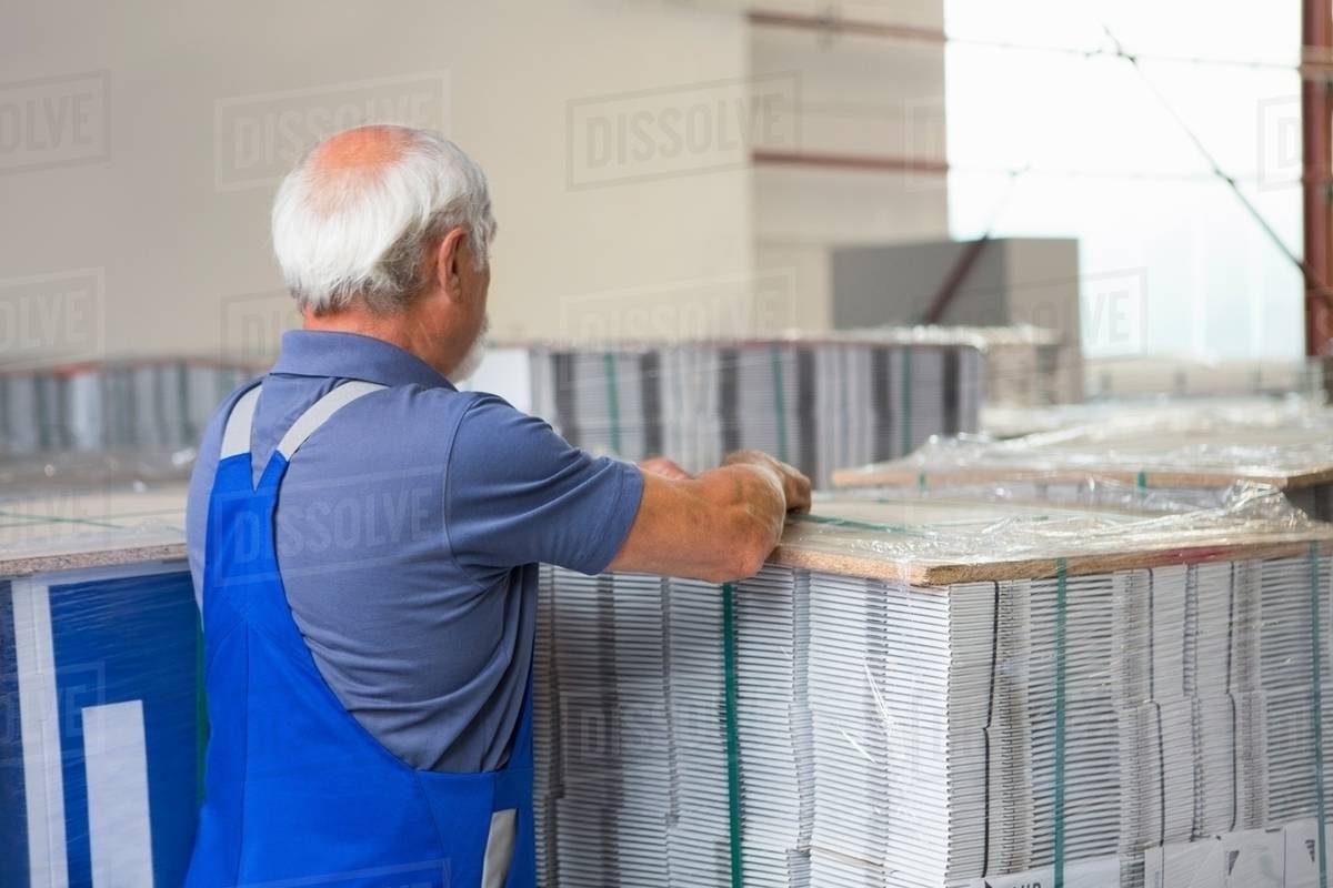 Factory worker moving and stacking cardboard - Royalty-free Stock Photo ...