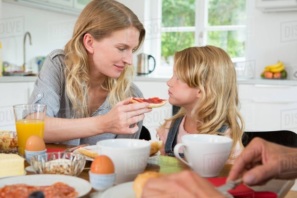 Mother offering daughter some food - Royalty-free Stock Photo | Dissolve