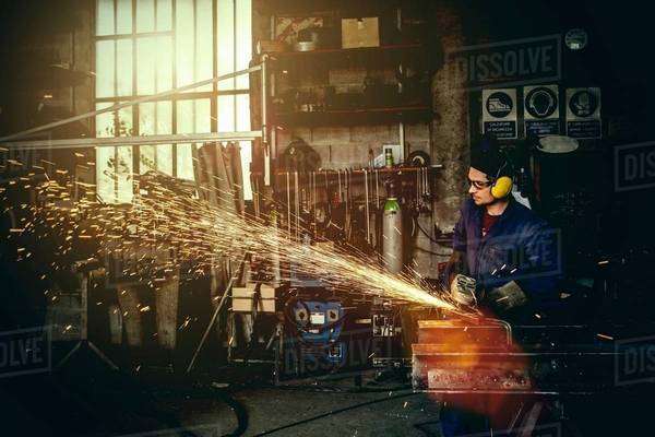 Welder cutting iron in workshop - Stock Photo - Dissolve