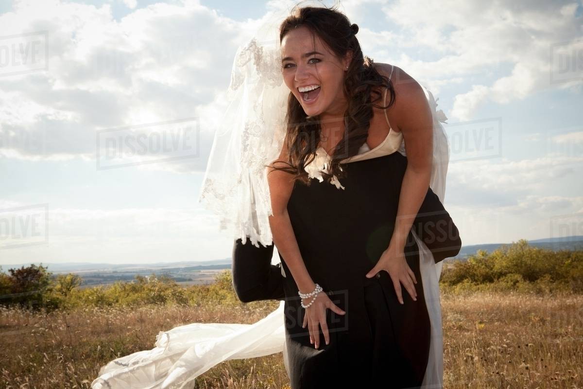 Newlywed groom carrying bride outdoors - Royalty-free Stock Photo ...