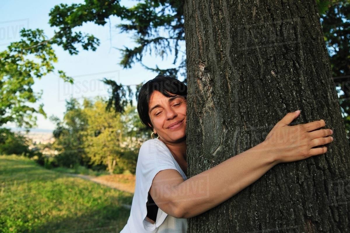 Woman hugging tree in forest - Royalty-free Stock Photo | Dissolve