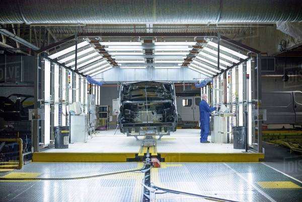 Worker and vehicle in inspection station in car factory - Stock Photo ...
