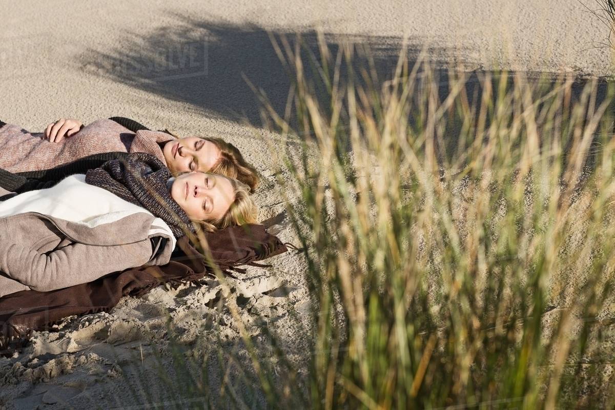 Women napping on beach - Royalty-free Stock Photo | Dissolve