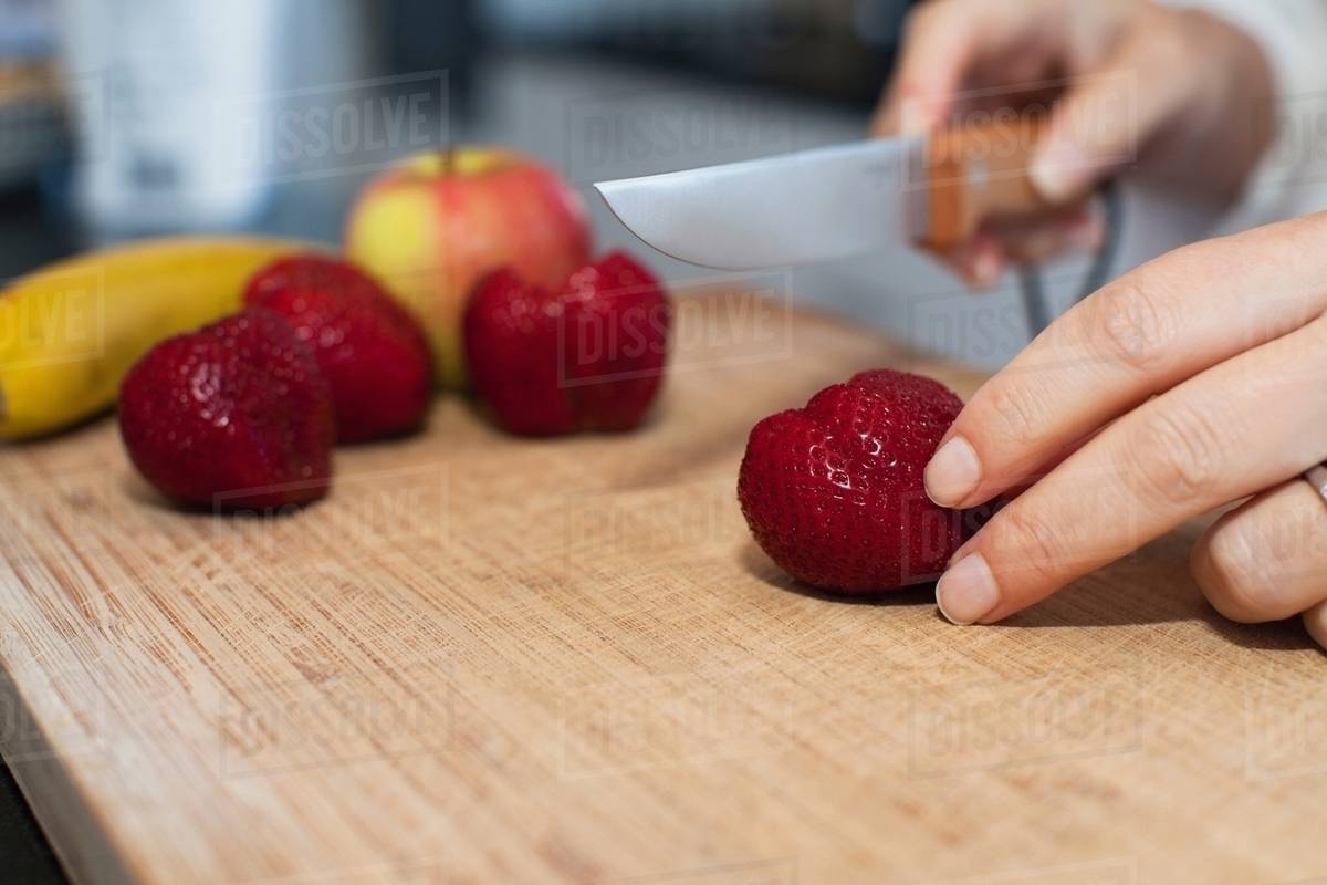 Close up of woman cutting fruit - Royalty-free Stock Photo | Dissolve