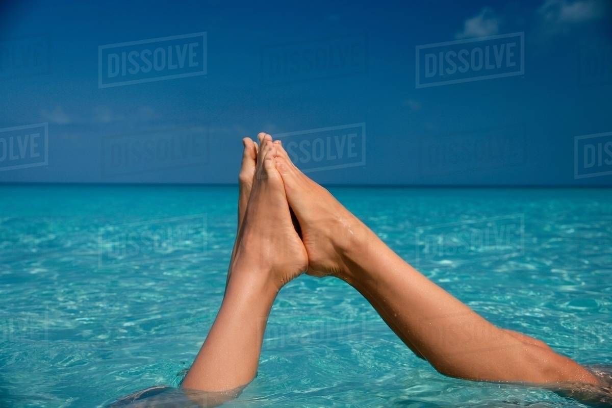 Feet touching in tropical water - Royalty-free Stock Photo | Dissolve