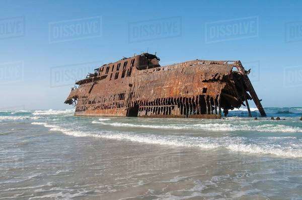 Shipwreck stranded on beach - Stock Photo - Dissolve