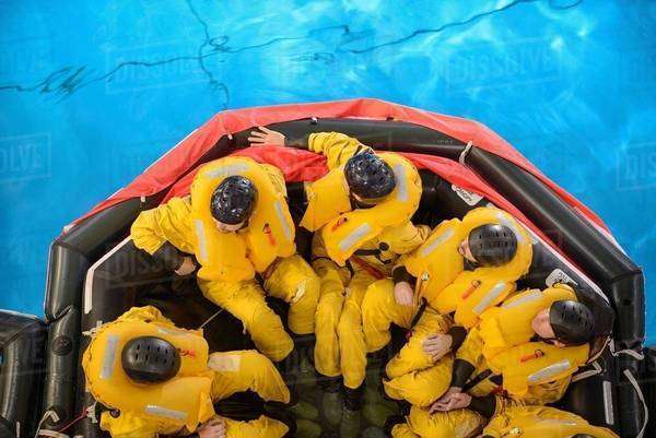 Offshore oil workers in raft being trained in sea ditching survival in ...