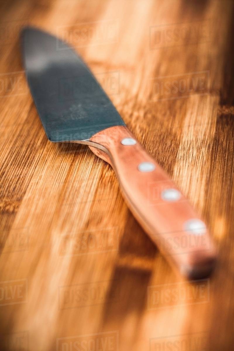 Close up of knife on wooden table - Royalty-free Stock Photo | Dissolve
