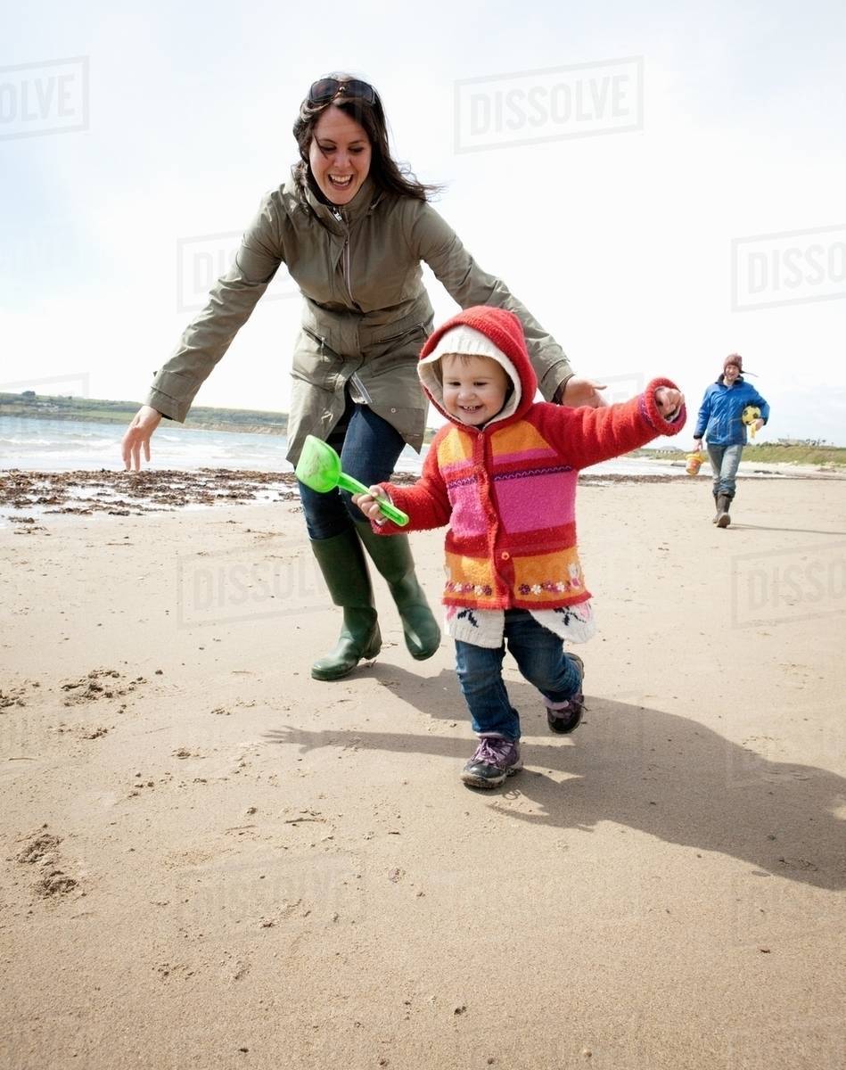 Mother chasing daughter on beach - Royalty-free Stock Photo | Dissolve