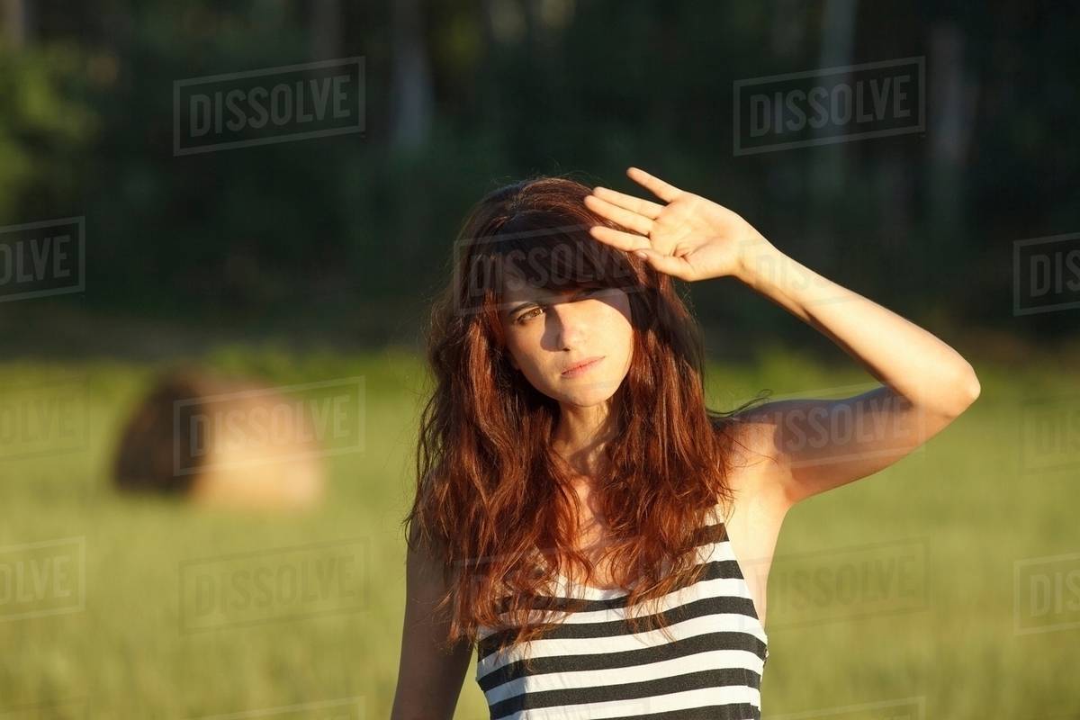 Woman shielding her eyes from sun - Royalty-free Stock Photo | Dissolve
