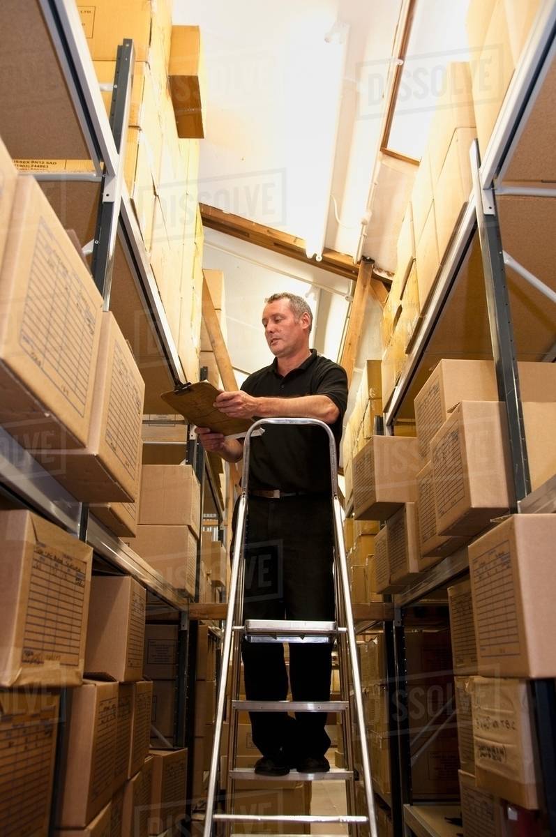 Worker stacking cardboard boxes - Royalty-free Stock Photo | Dissolve