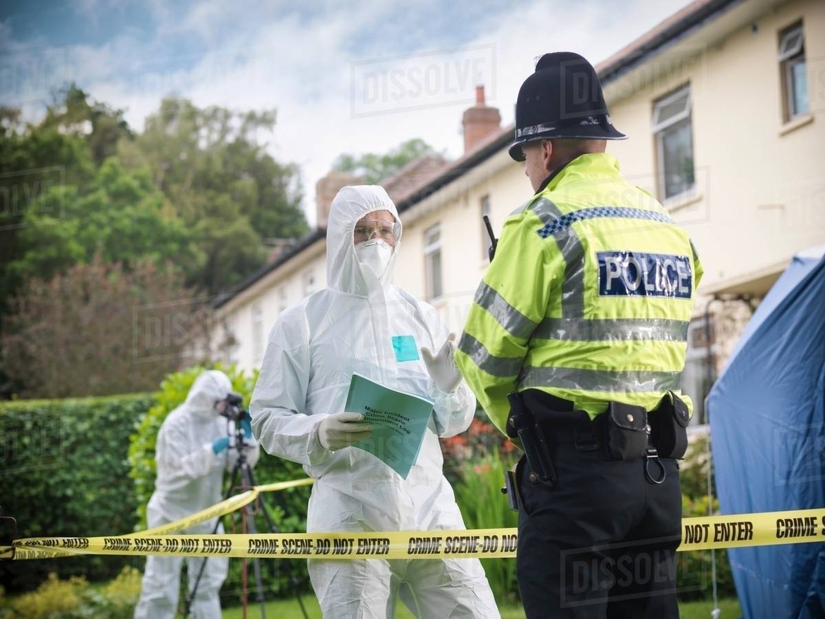 Policeman talking to forensic scientists at crime scene - Stock Photo ...
