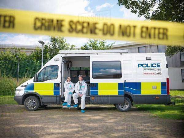 Portrait of forensic scientists sitting in police incident van at crime ...