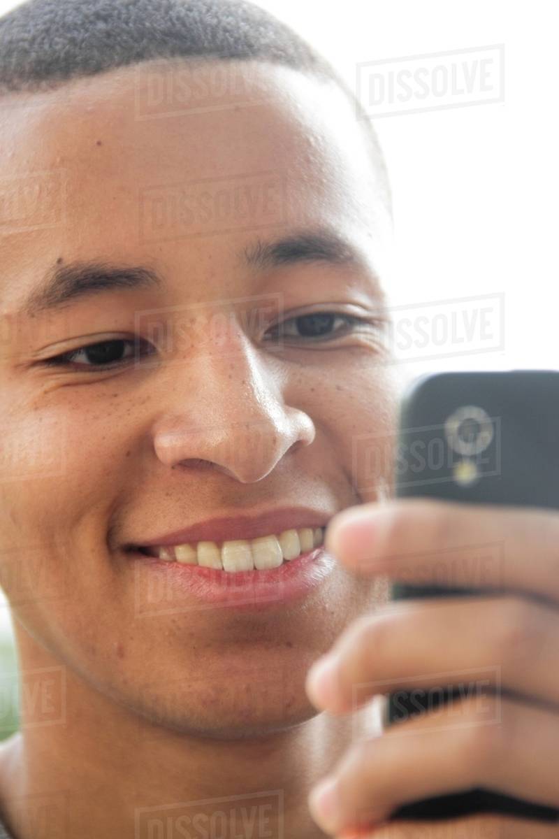 Teenage boy using cell phone outdoors - Royalty-free Stock Photo | Dissolve