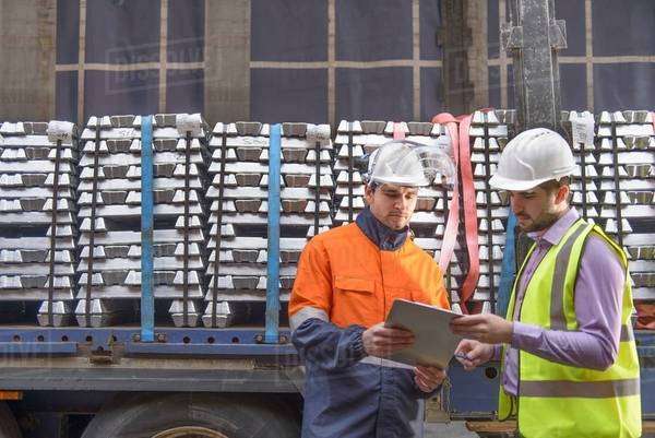 Workers inspecting loading documents for aluminium ingots - Stock Photo ...