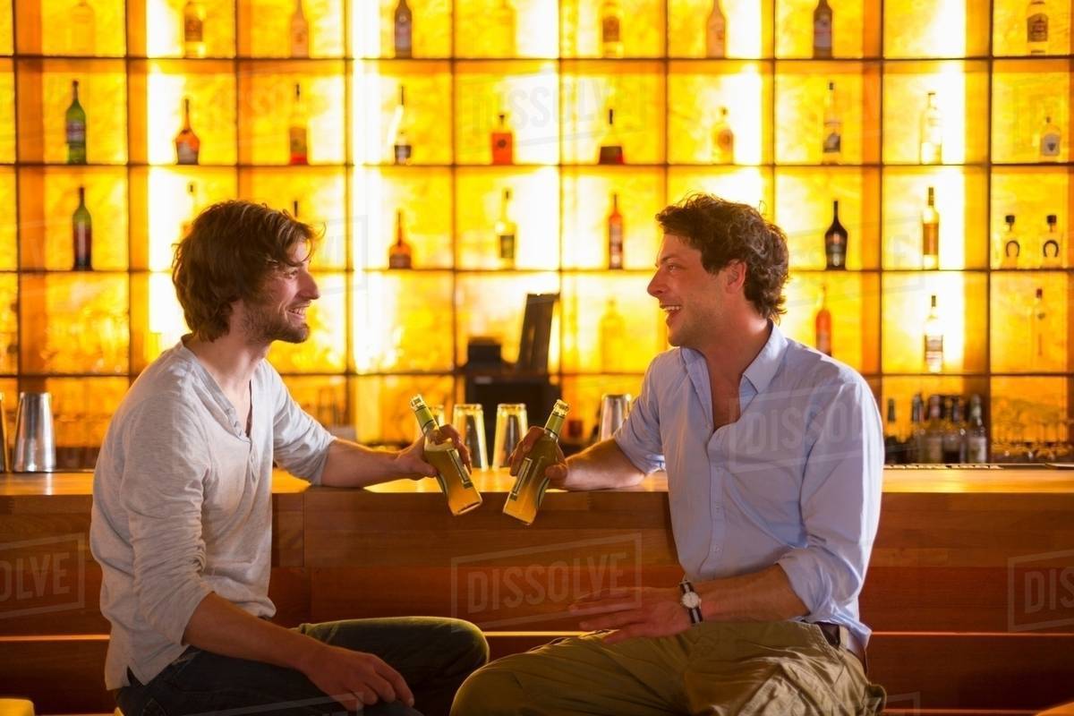 Two men sitting at bar with bottles of beer - Royalty-free Stock Photo ...