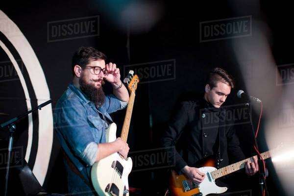 Two men playing guitars on stage - Royalty-free Stock Photo | Dissolve