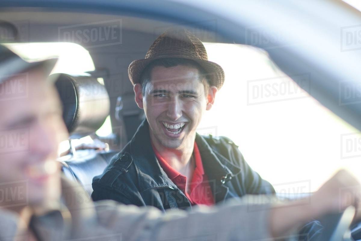 Two young men driving in car - Royalty-free Stock Photo | Dissolve