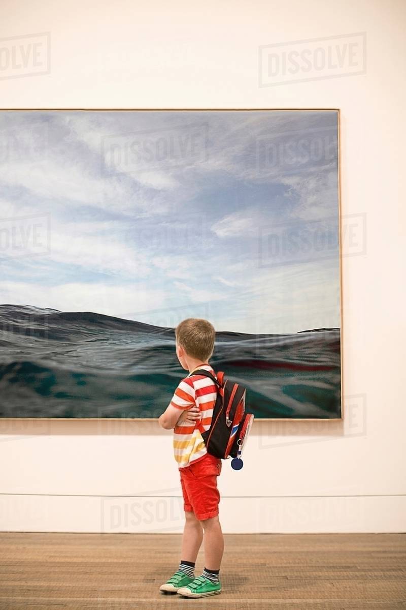 Young boy looking at picture in gallery - Stock Photo - Dissolve