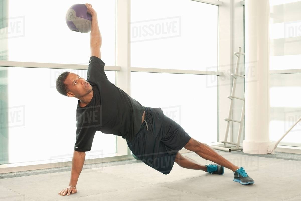 Man stretching using exercise ball - Stock Photo - Dissolve