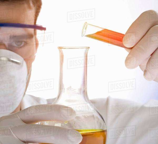 Close up of scientist pouring liquid from test tube - Royalty-free ...