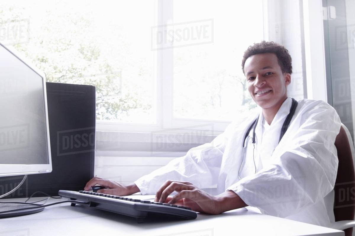Scientist wearing lab coat working on computer - Royalty-free Stock ...