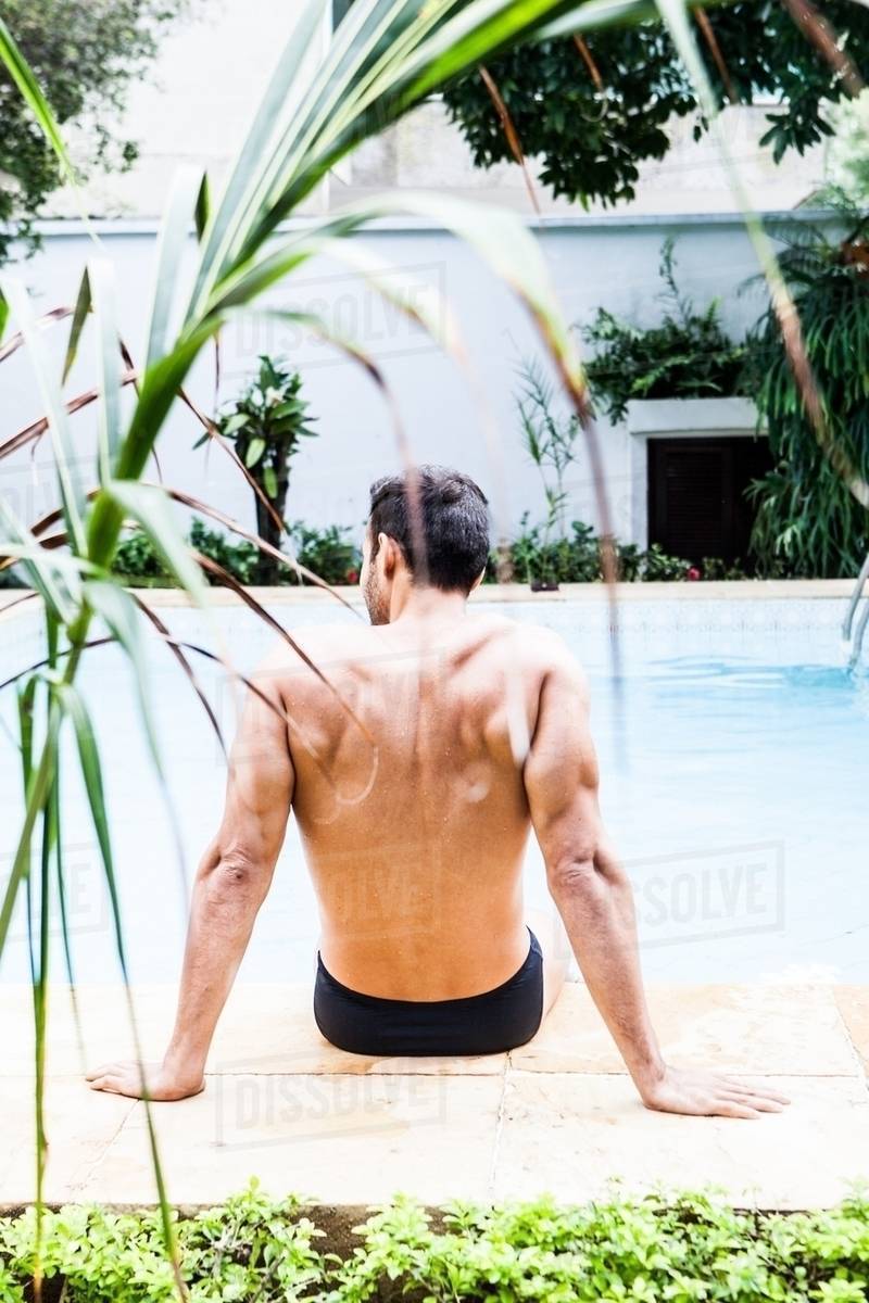 Man sitting at poolside - Royalty-free Stock Photo | Dissolve