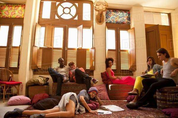 Students chilling out and studying in living room - Stock Photo - Dissolve