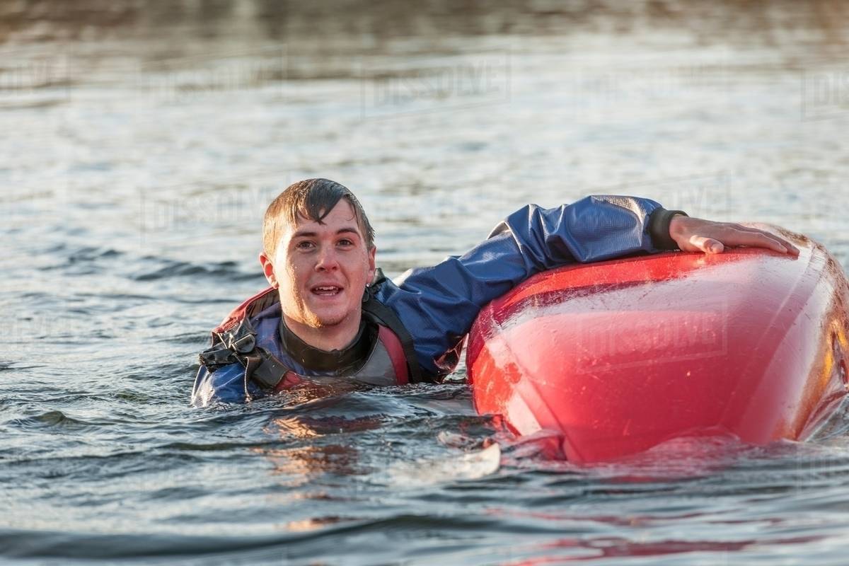Young man falling in water with kayak - Royalty-free Stock Photo | Dissolve