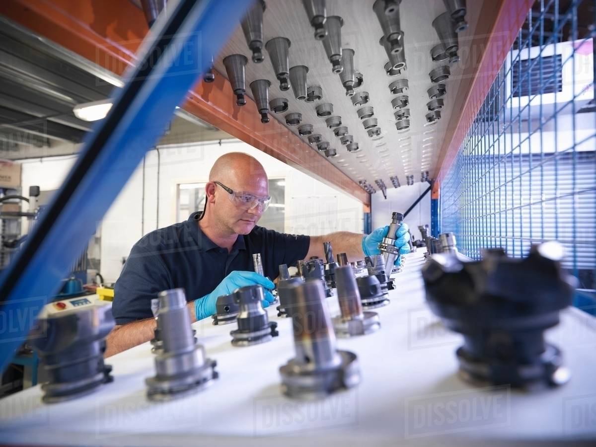 Engineer selecting lathe cutting tools in factory - Stock Photo - Dissolve